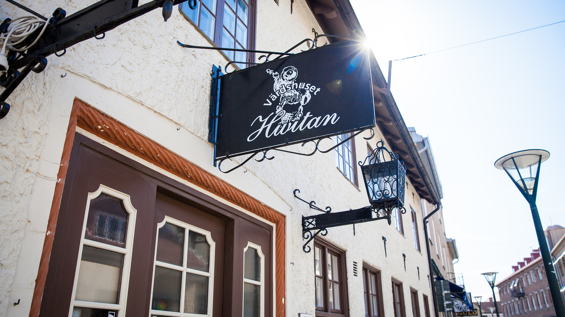 Gammalt stenhus med plåtskylt med texten "Hwitan".