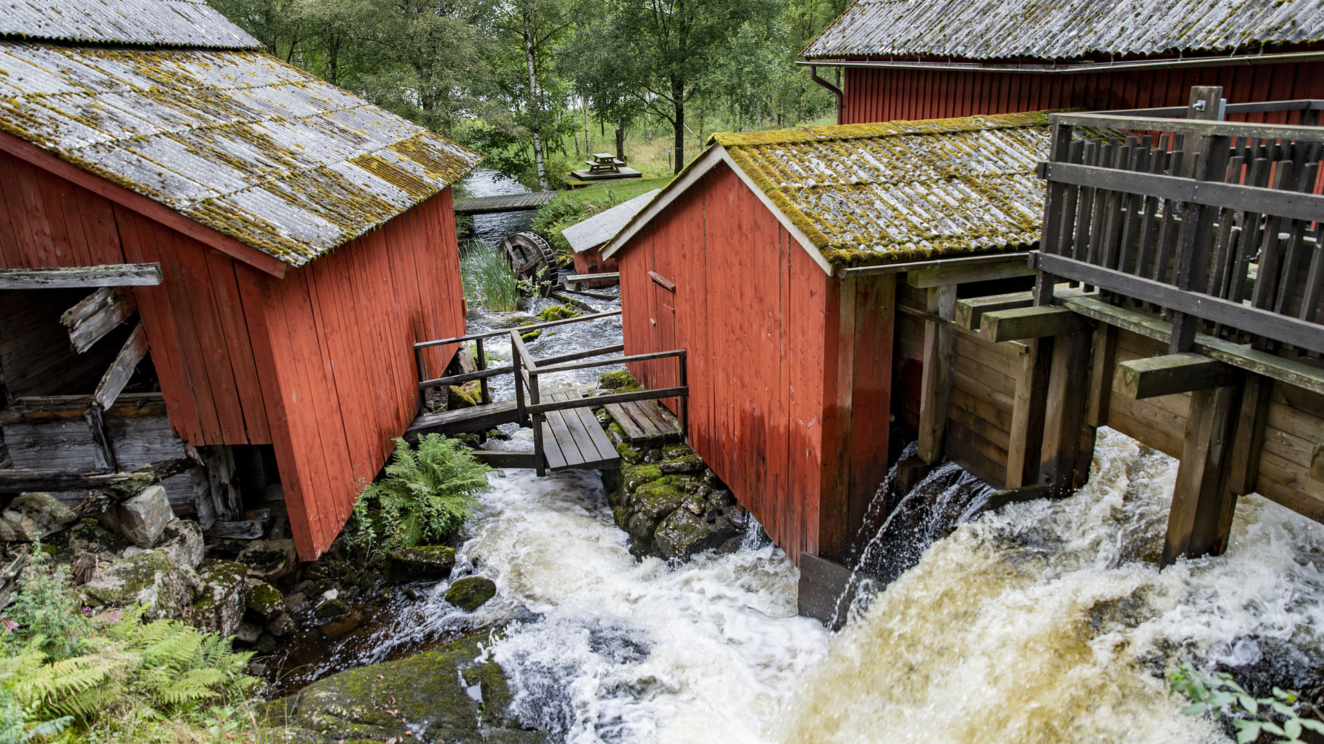 En fors flyter mellan två röda hus