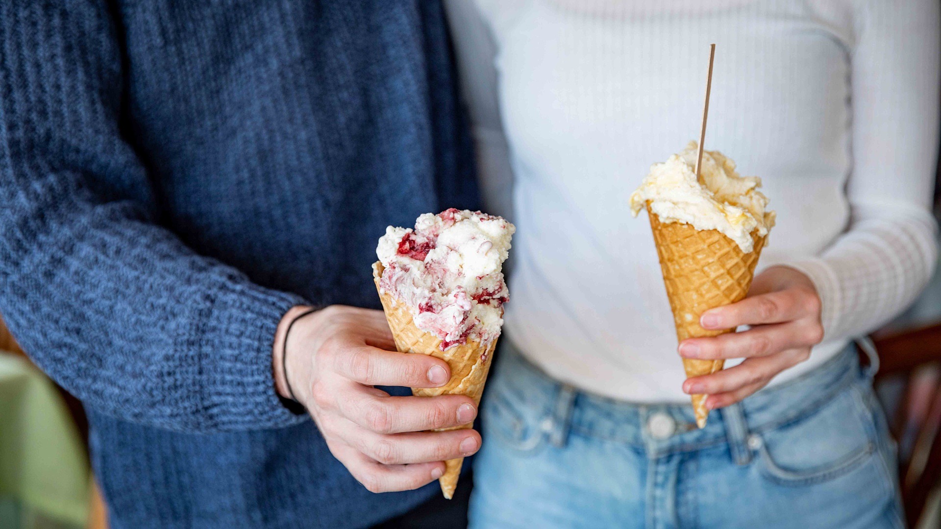 två personer håller varsin strut med glass