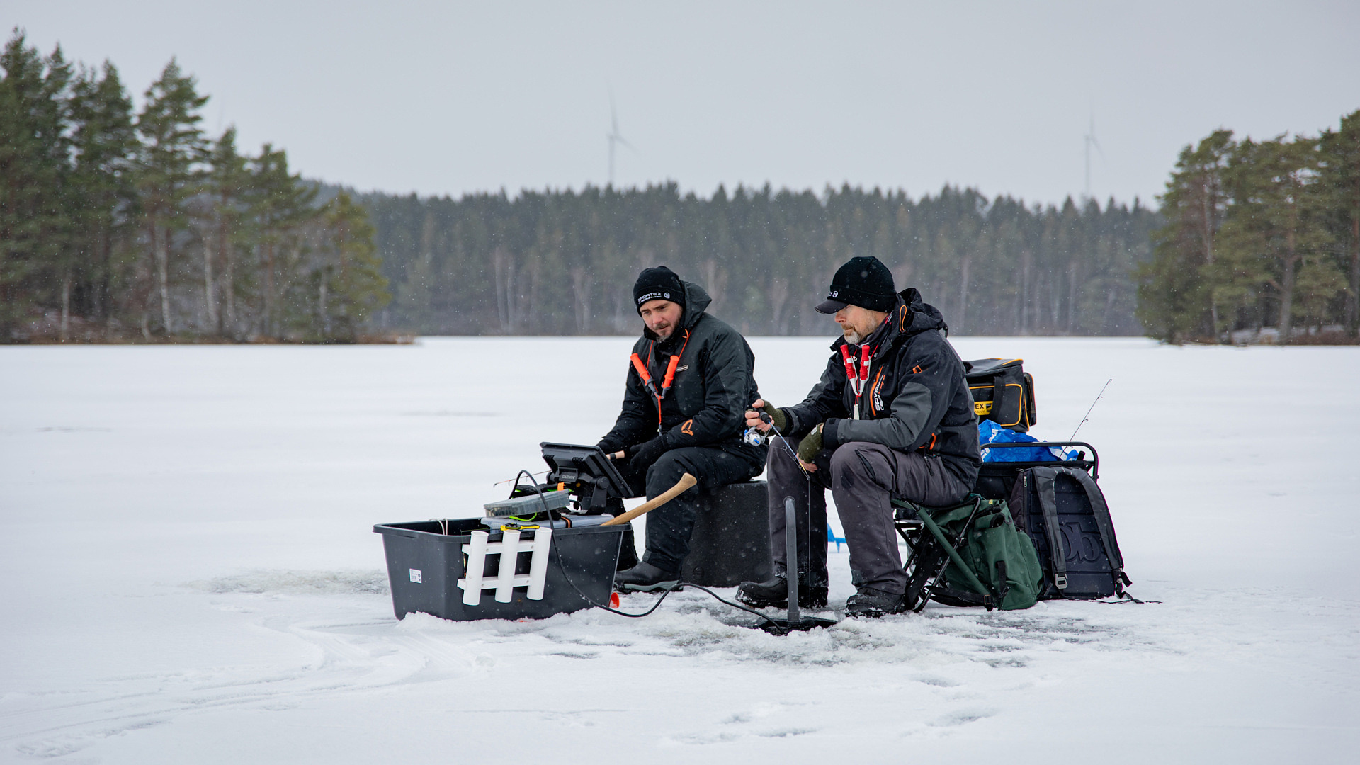 två fiskare isfiskar på sjö