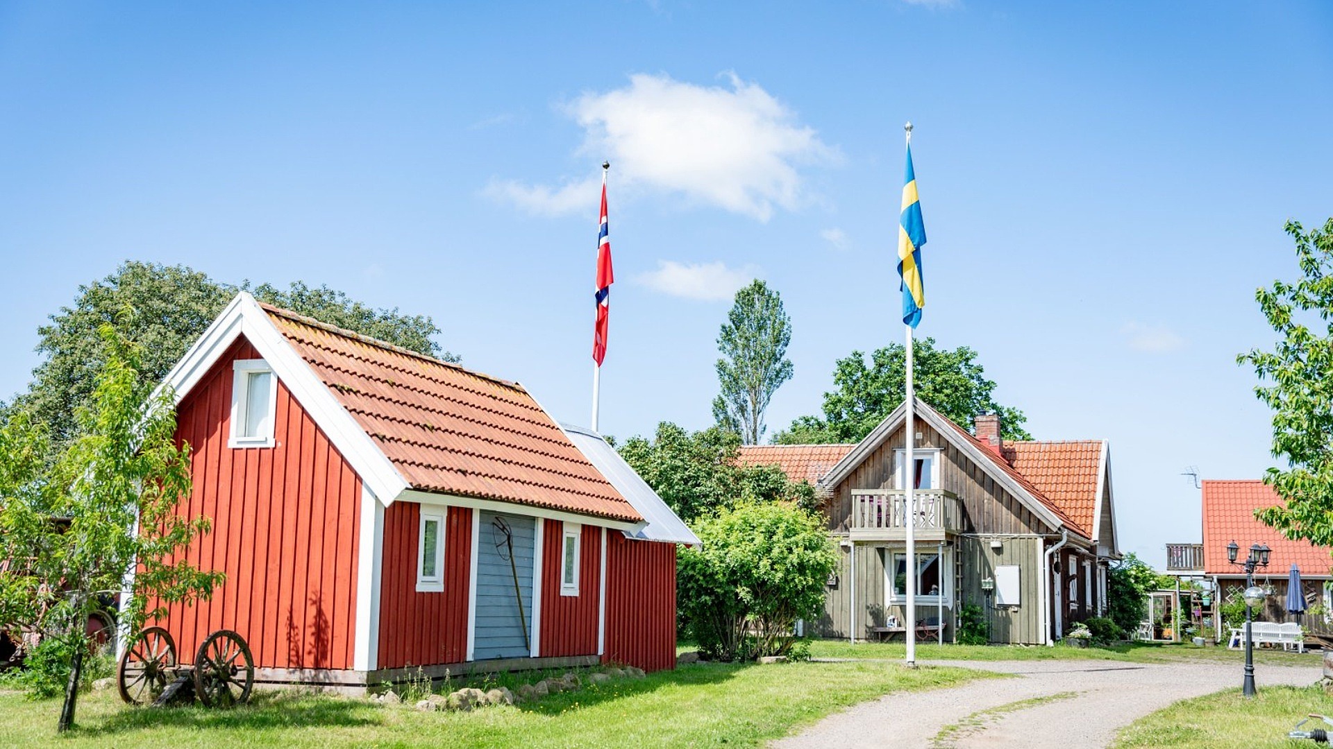 En röd stuga och ett grått större hus.