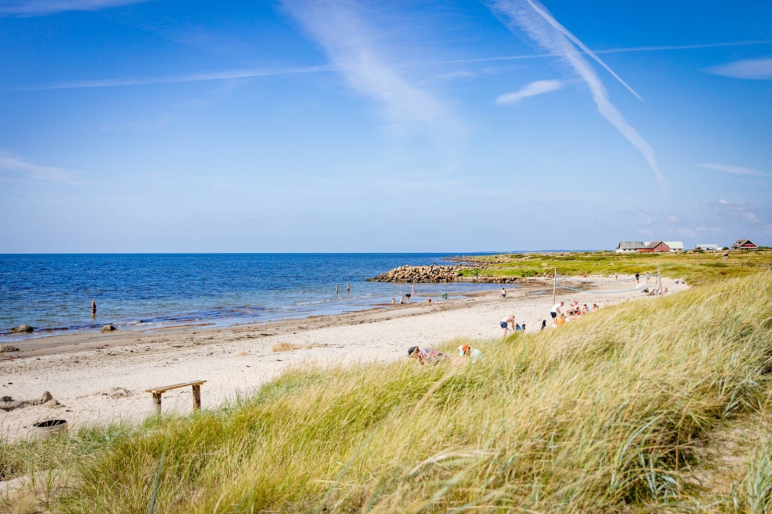 En vacker sandstrand omgiven av strandängar och öppna landskap ...